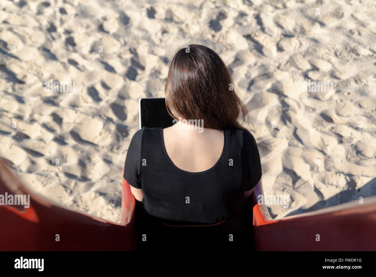 Woman seated on a slide Stock Photo - Alamy