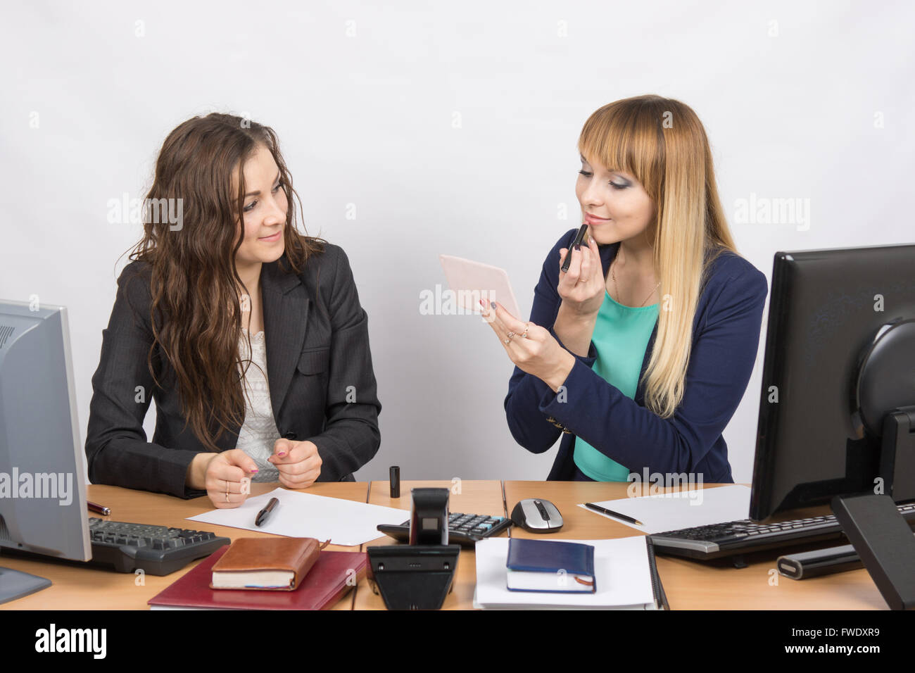Office employee observes as lipstick colleague sitting beside his desk ...