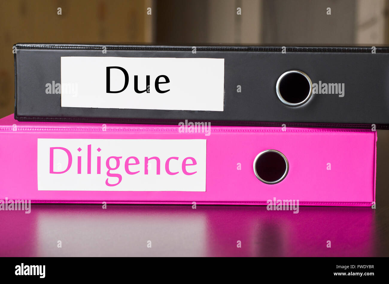Bright office folders over dark background and due diligence text ...