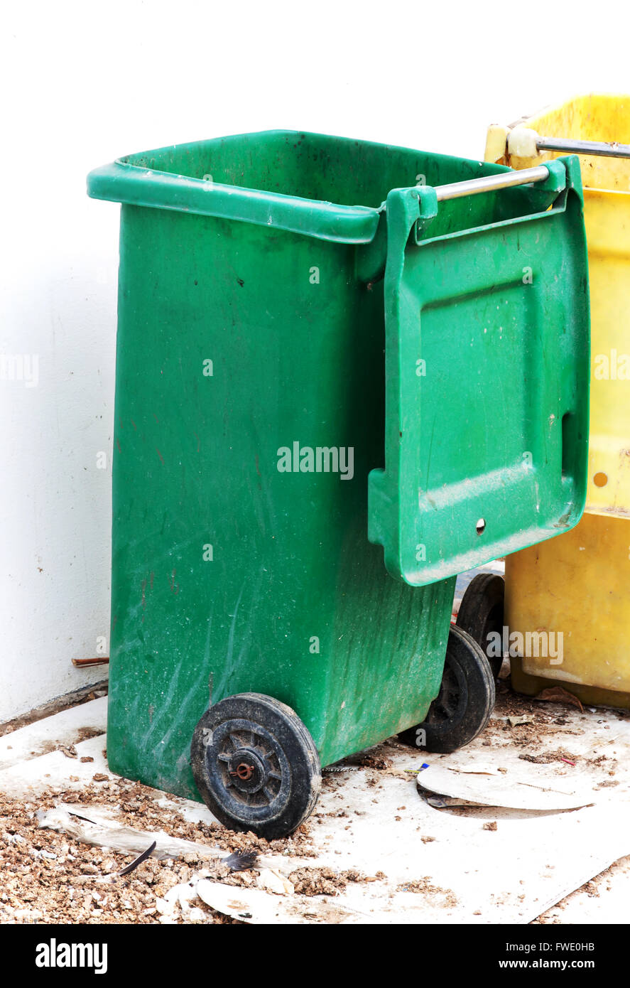 Trash open the tank lid facing white wall. and yellow bins Stock Photo ...