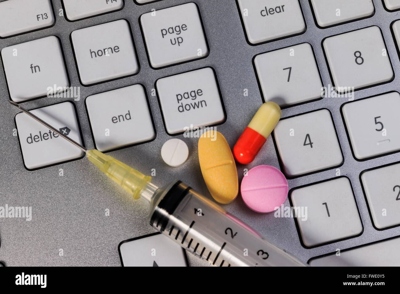 Pills capsule and syringe on computer keyboard, concept on medicine ...