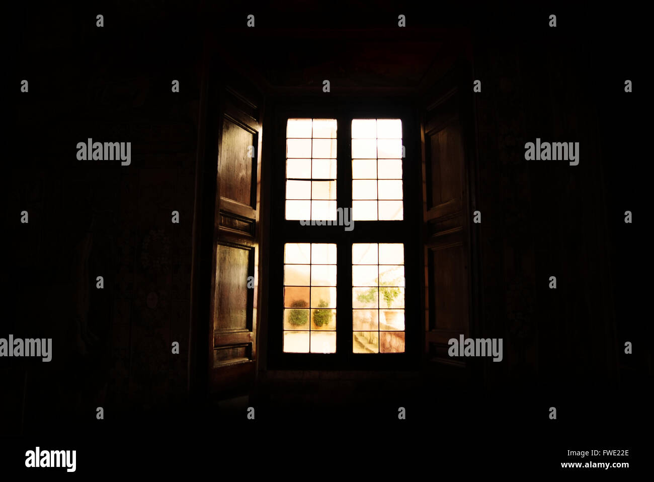 Open old window with wooden shutters in dark room. Inside view Stock ...