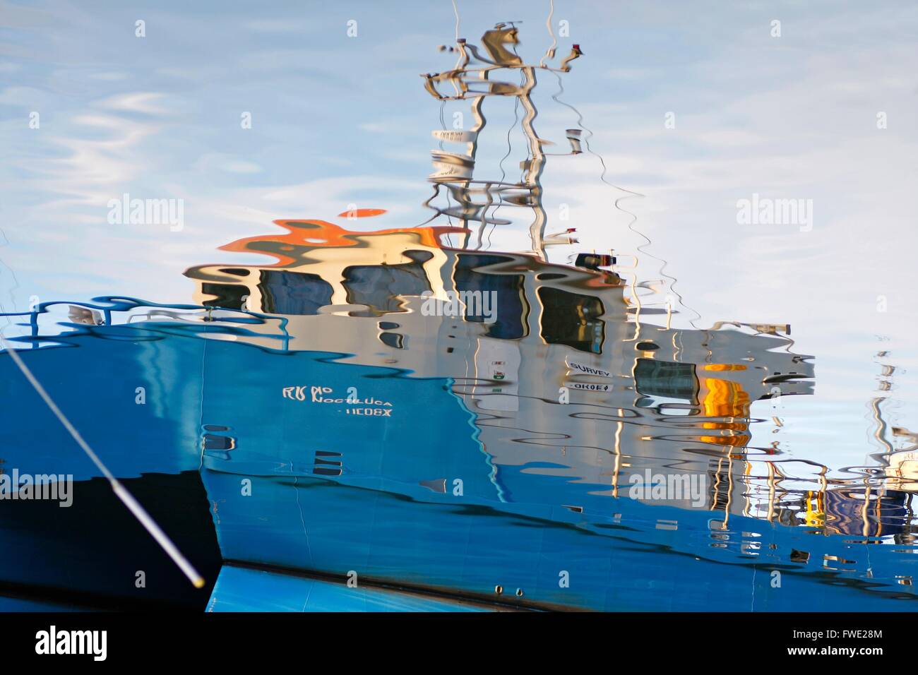 Blue ship reflected in water ripples Stock Photo - Alamy