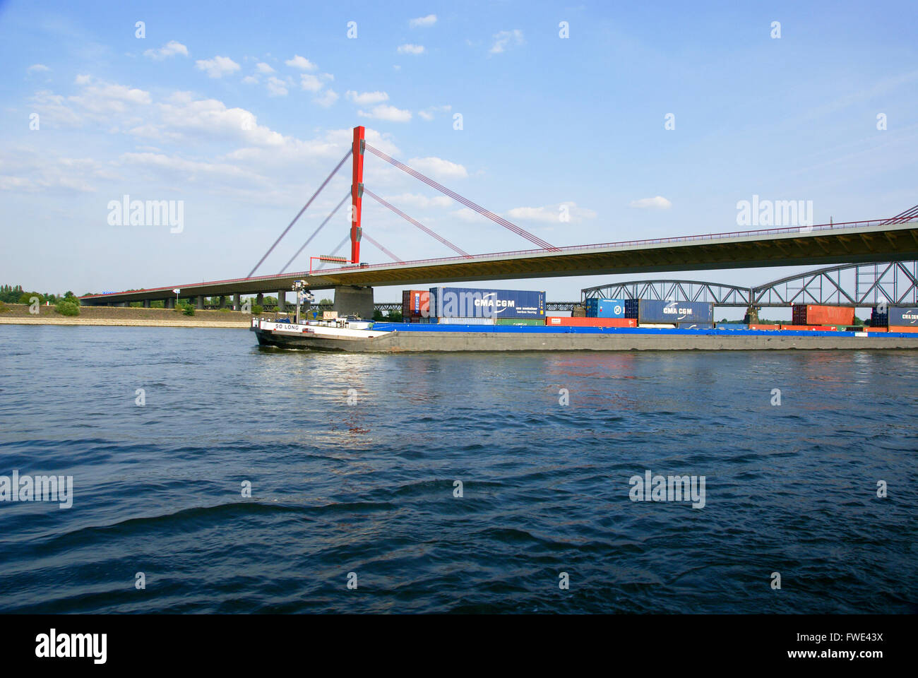 A barge passes under a bridge on the river Rhine near Arnhem, Nederland ...