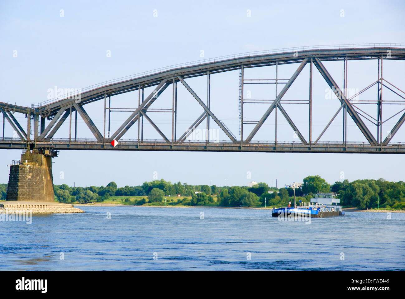 A barge passes under a bridge on the river Rhine near Arnhem, Nederland ...