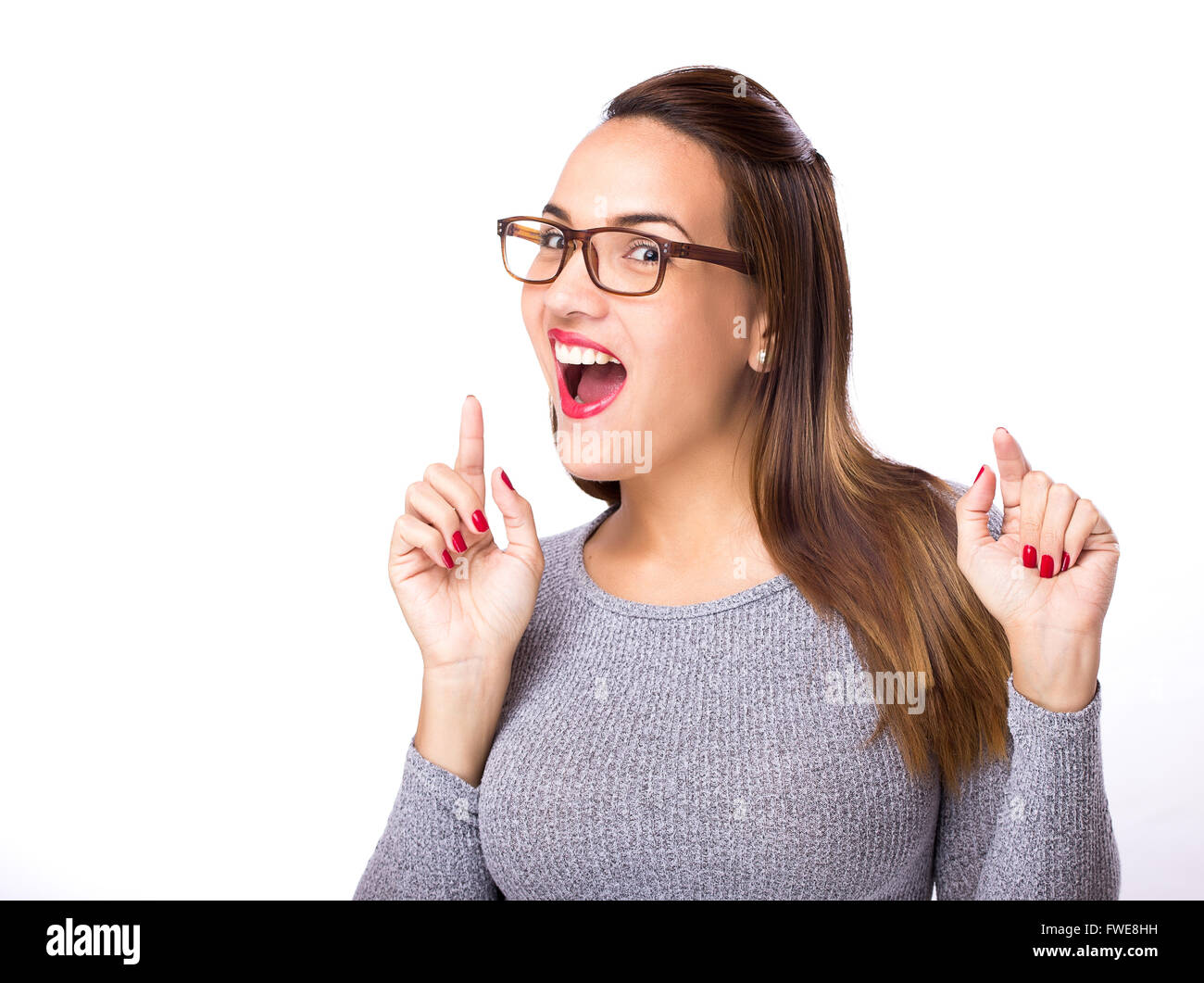 young woman looking excited against white background Stock Photo - Alamy