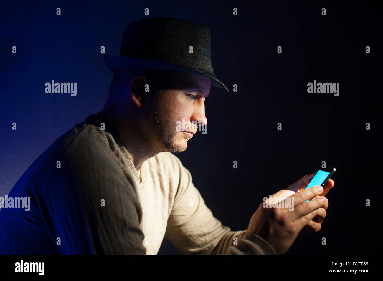 Handsome man sitting using mobile smartphone dark background Stock ...