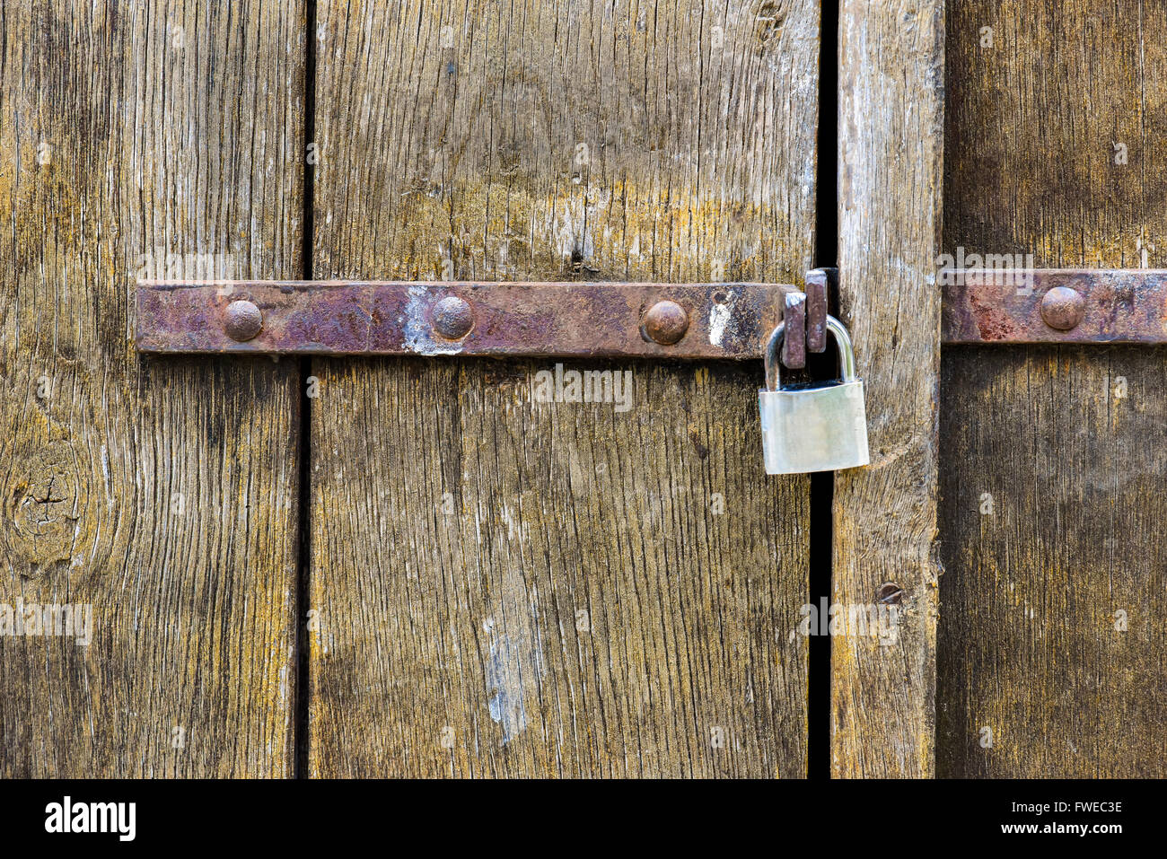 Wooden door with padlock steel in natural light Stock Photo - Alamy