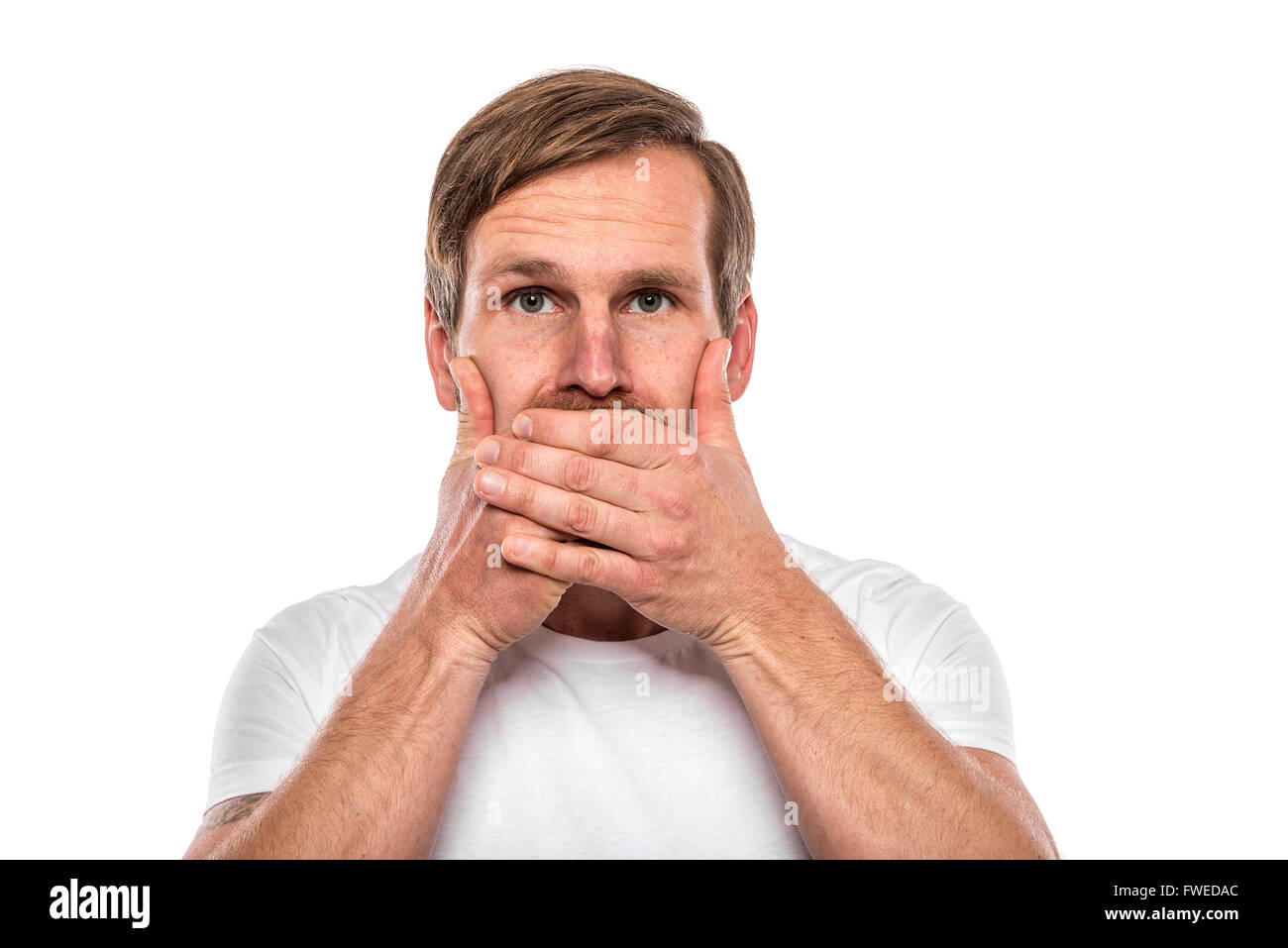 Man covering mouth with hands and looking at camera. Isolated on white ...