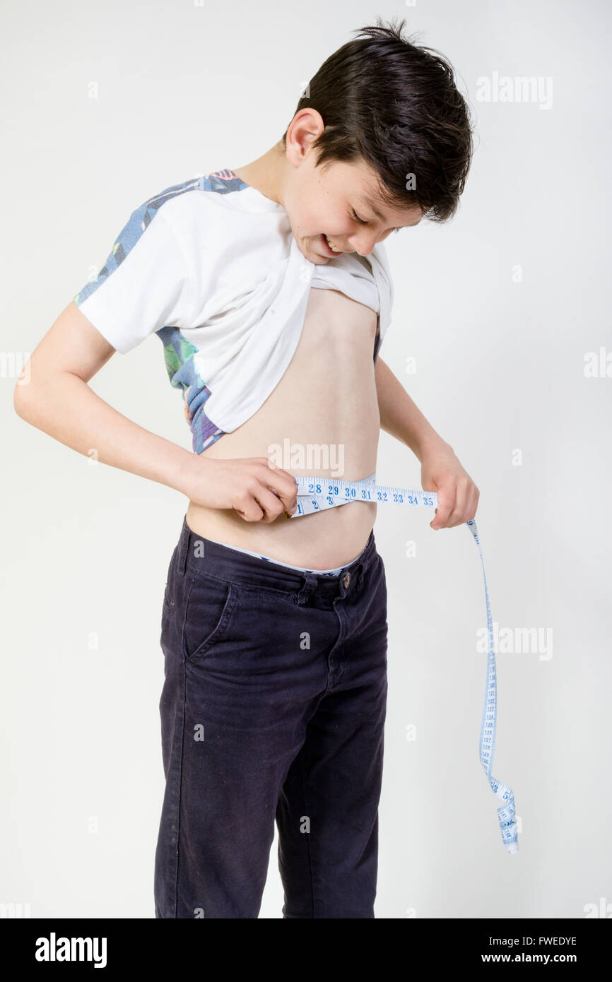 Young boy measuring his waist Stock Photo - Alamy