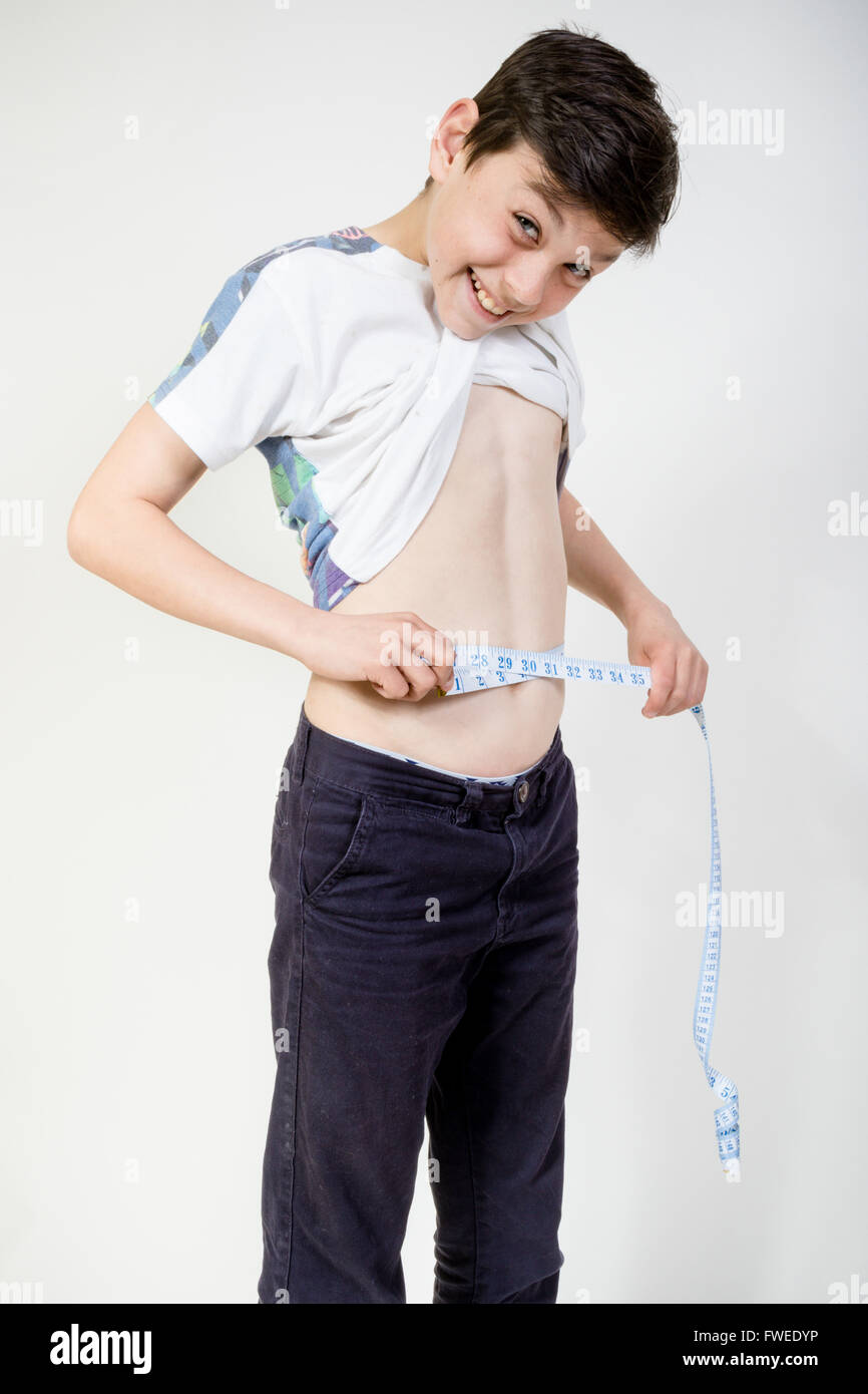 Happy young boy measuring his waist Stock Photo - Alamy