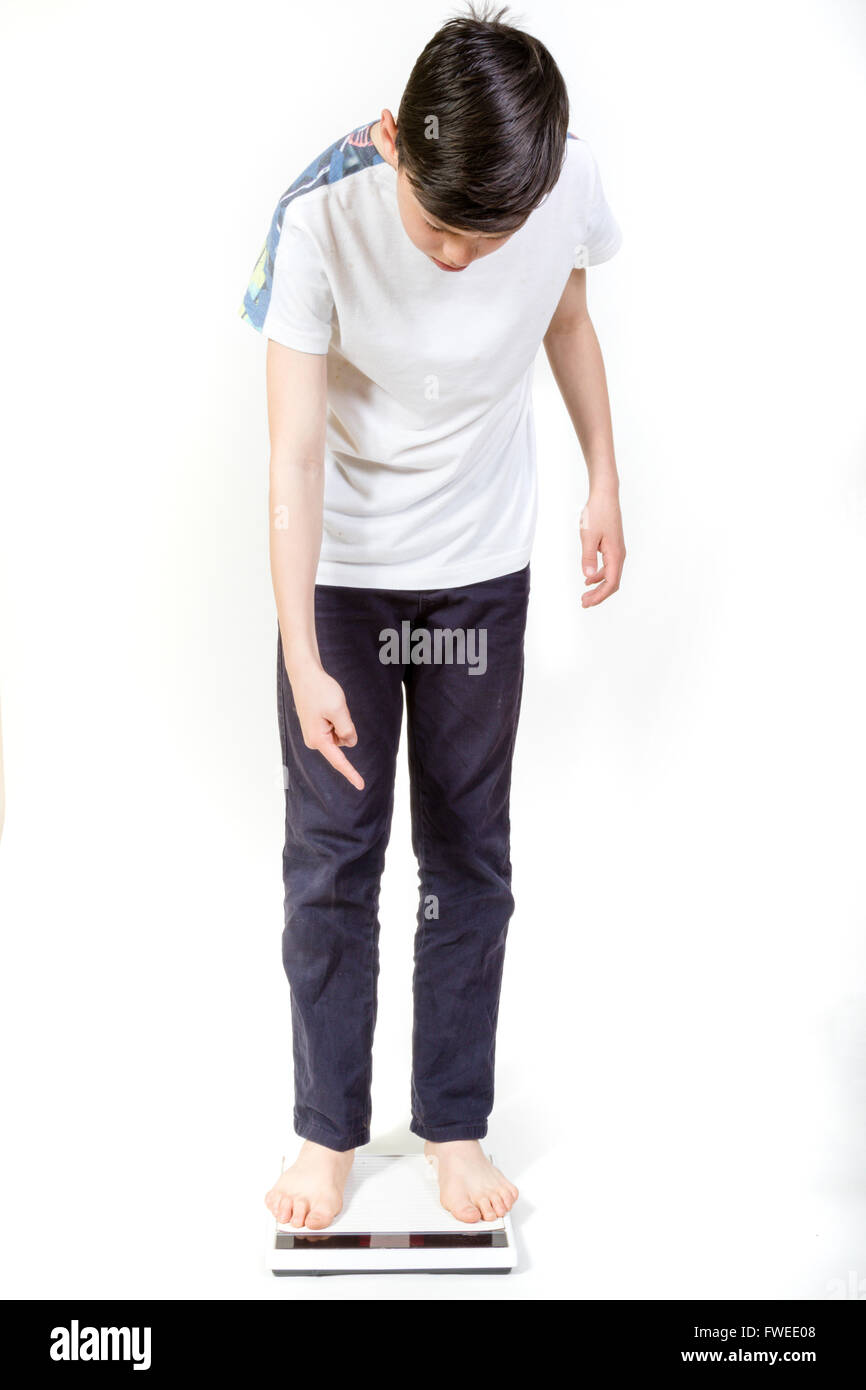 Young boy on scales pointing to his weight Stock Photo - Alamy