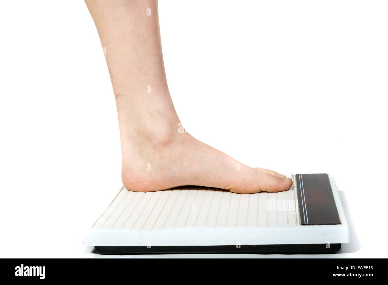 A foot stepping onto a scale Stock Photo - Alamy