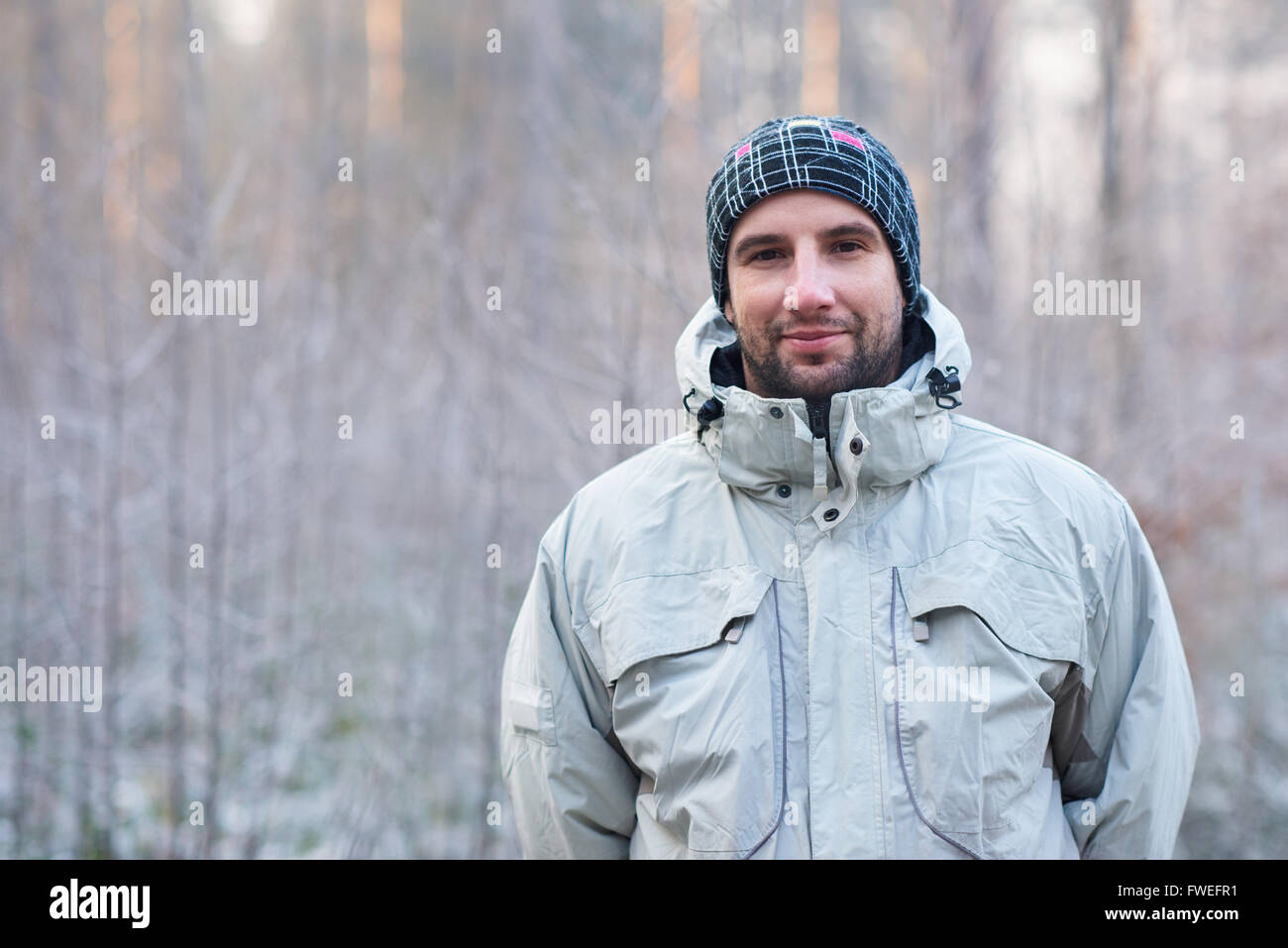 Portrait of a handsome man with rugged stubble, wearing warm clothes ...