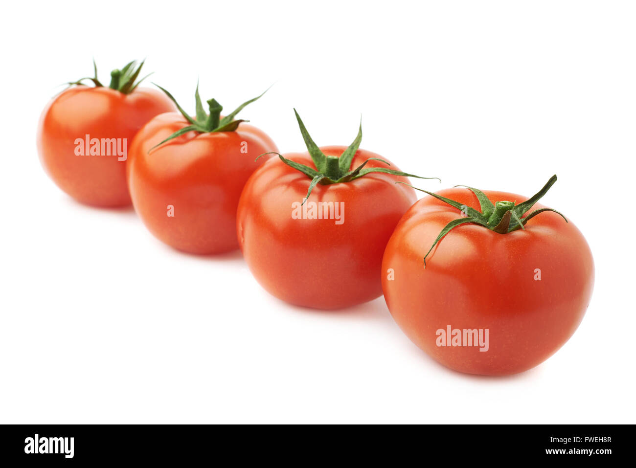 Four tomatoes in a line isolated Stock Photo - Alamy
