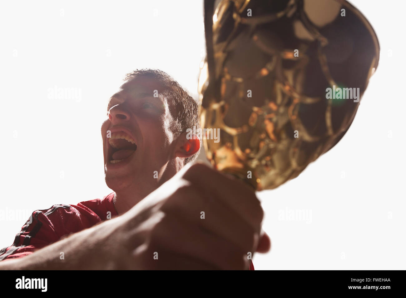 Athlete cheering with trophy cup Stock Photo - Alamy