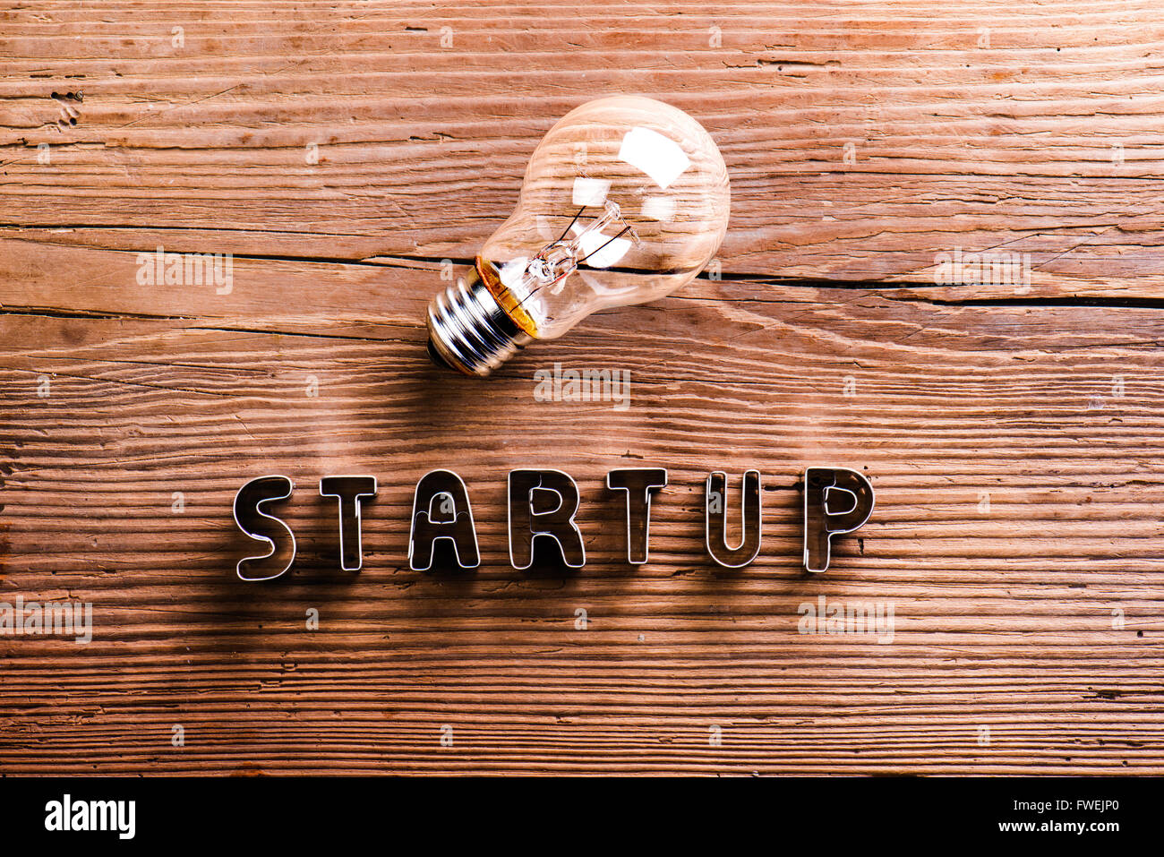 Office desk with start up sign and light bulb Stock Photo - Alamy