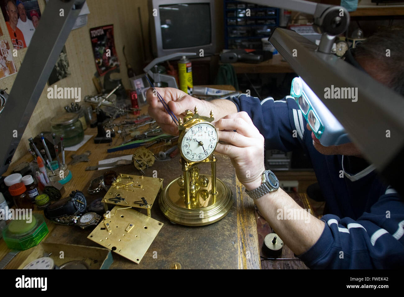 A watchsmith works on repairing a customers clock Stock Photo - Alamy
