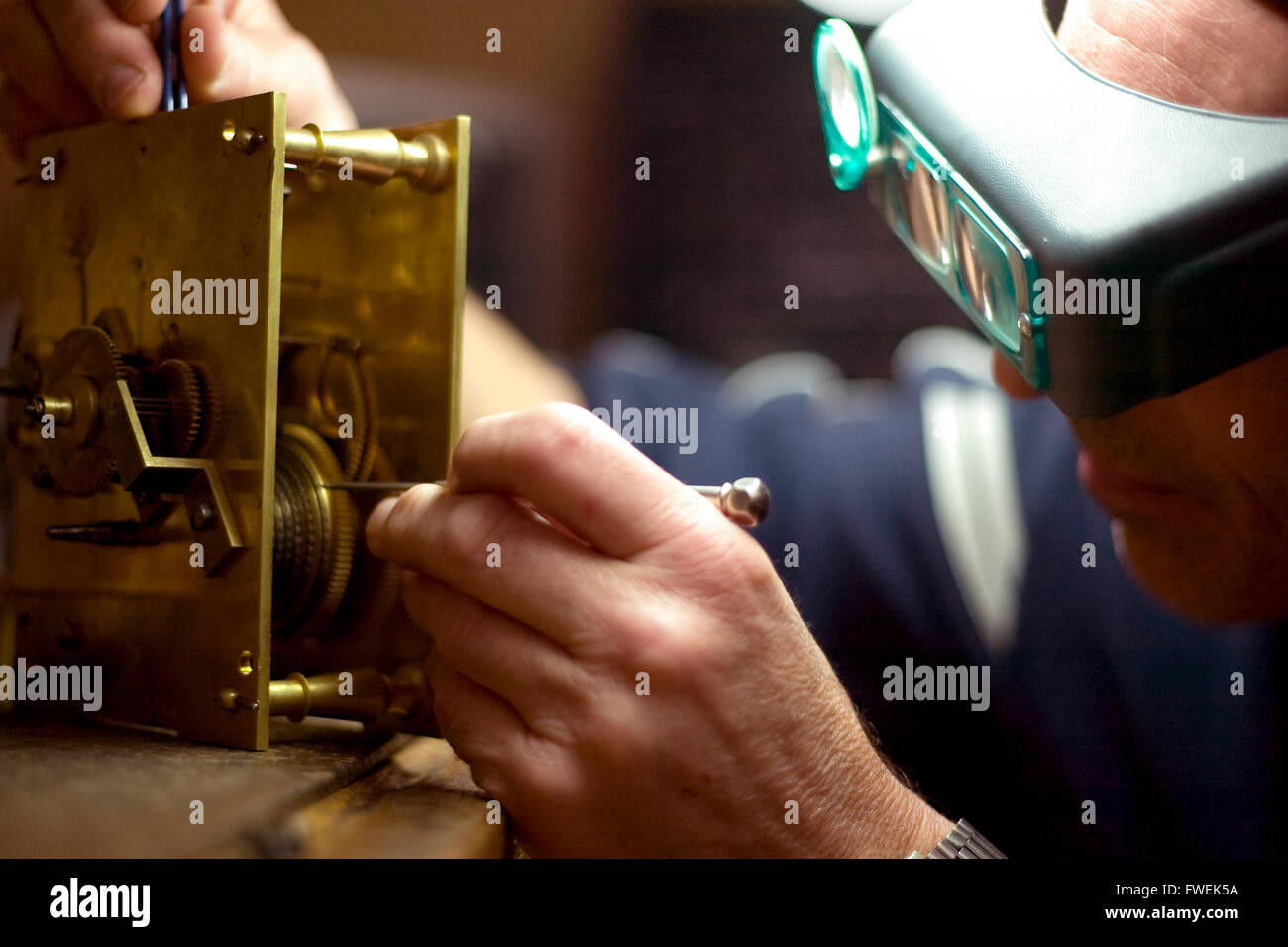 A watchsmith works on repairing a customers clock Stock Photo - Alamy