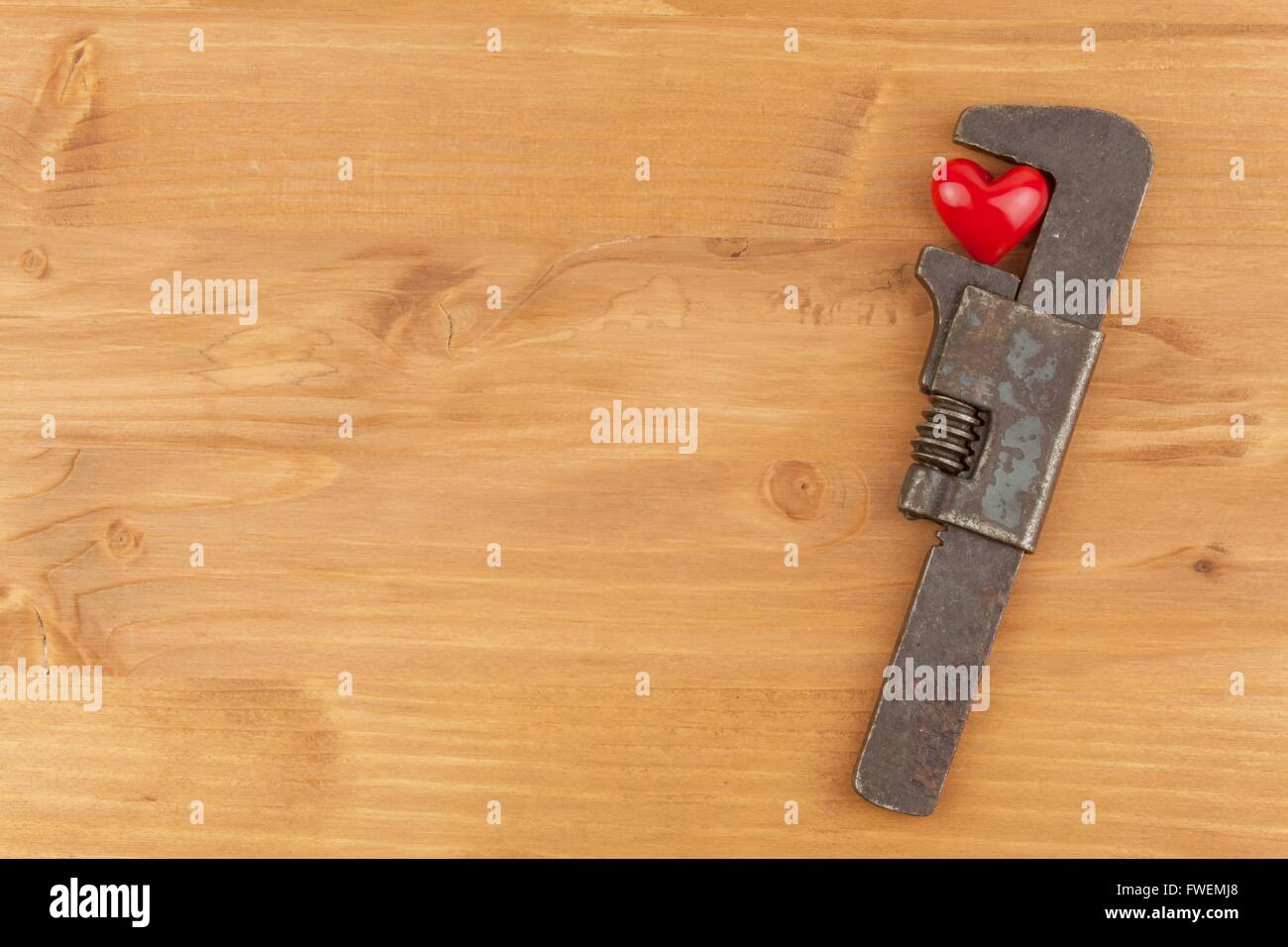 Heart under stress. Rusty vice crushed red heart. Working under stress ...