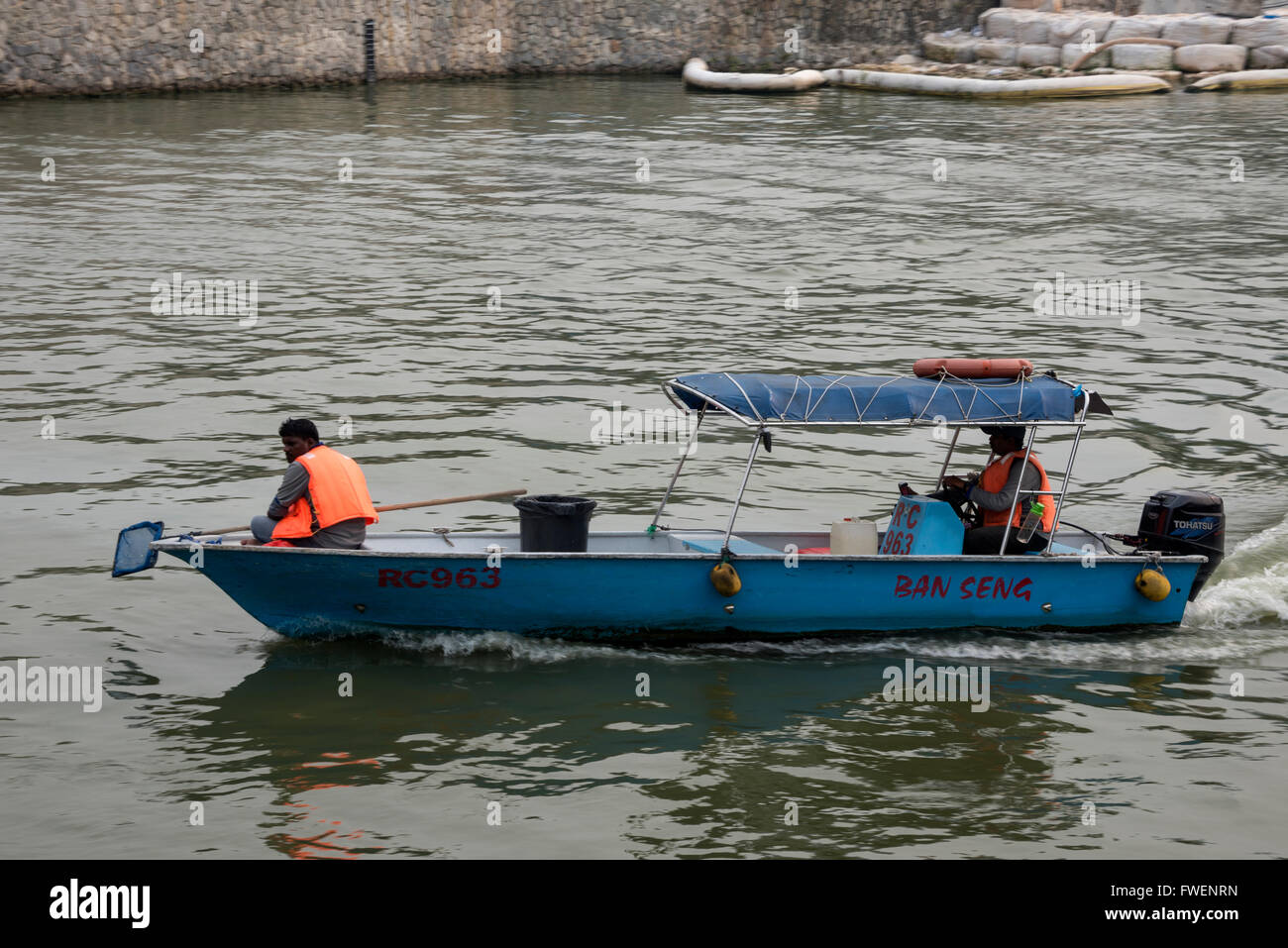 A boat crew cleaning up dumped rubbish and floating objects on the ...