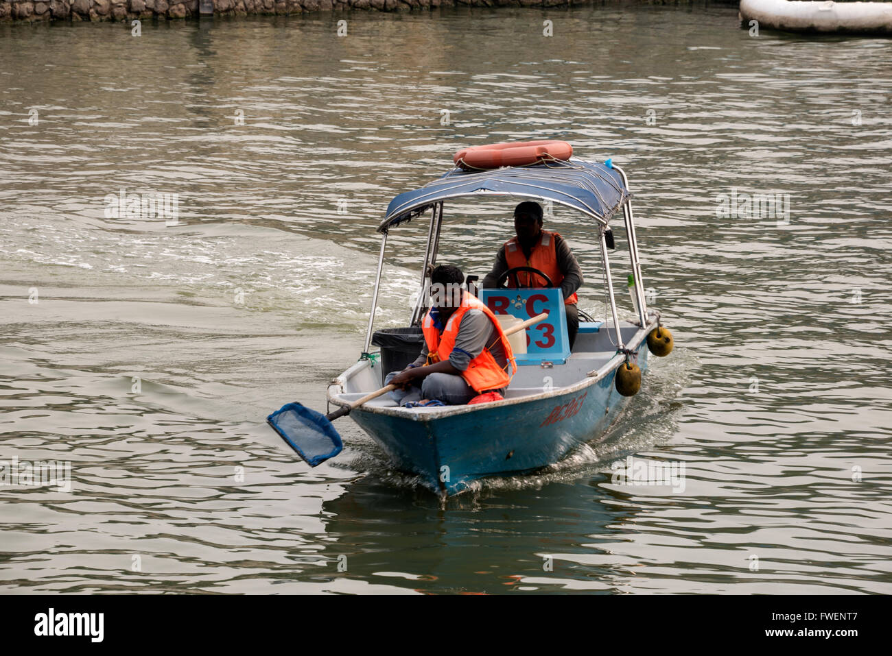 A boat crew cleaning up dumped rubbish and floating objects on the ...