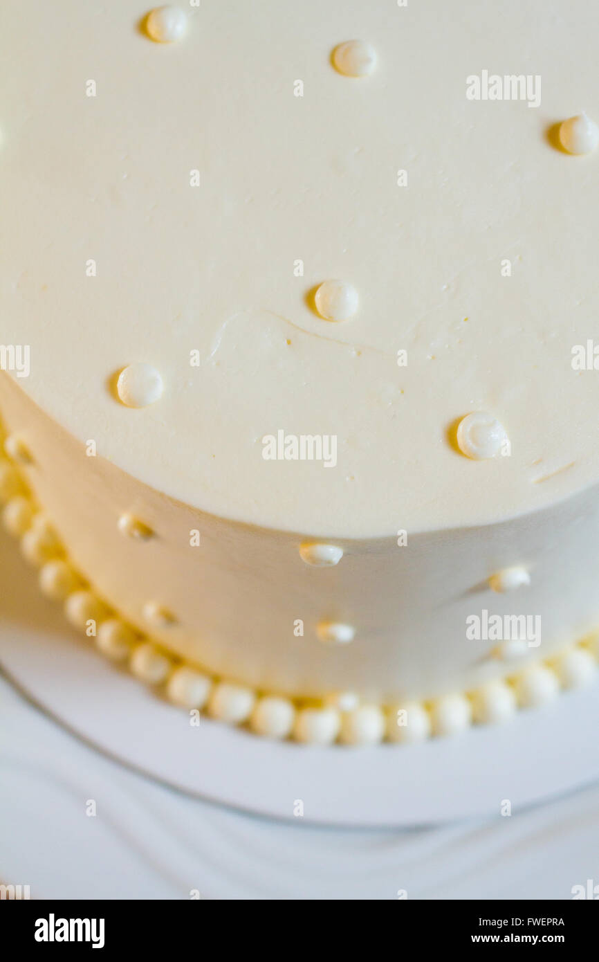 A very traditional white wedding cake at the reception for a bride and ...