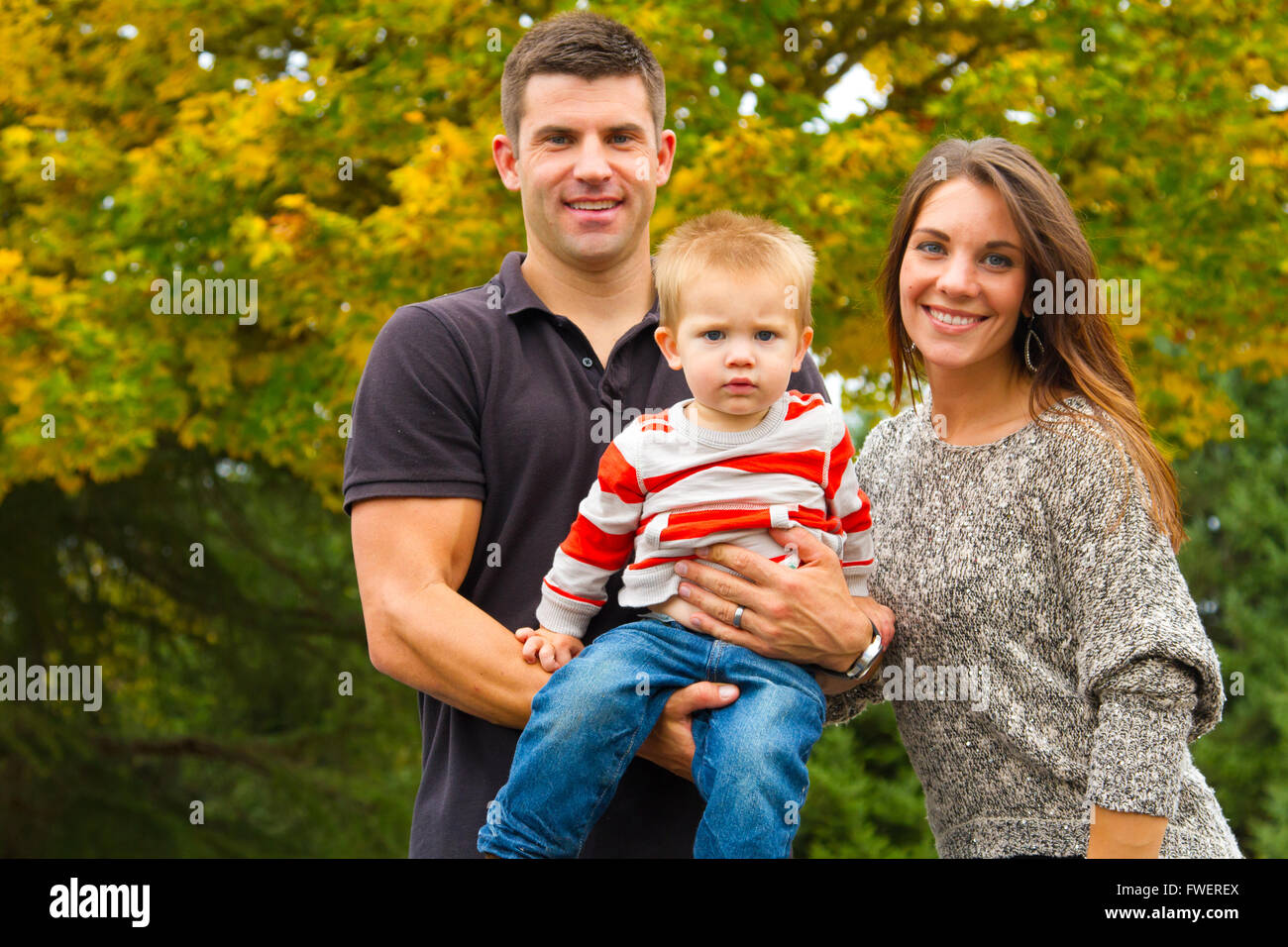 A husband and wife have their first child and pose for a portrait with ...