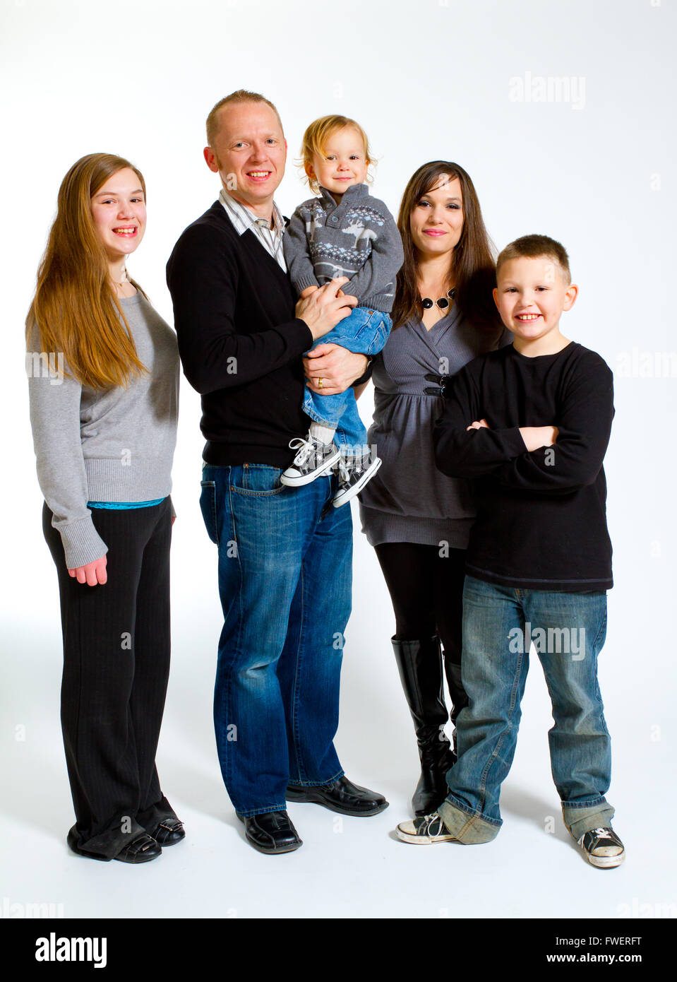 A family of five people on a white isolated background in the studio ...