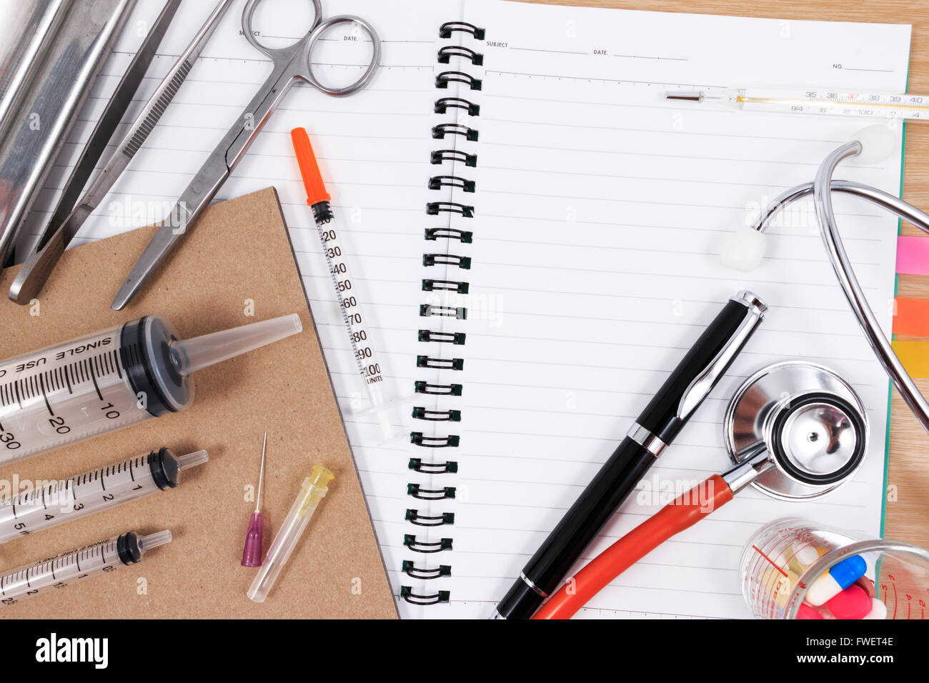 Stethoscope, syringes, scissors, pen and forceps on a white medical ...