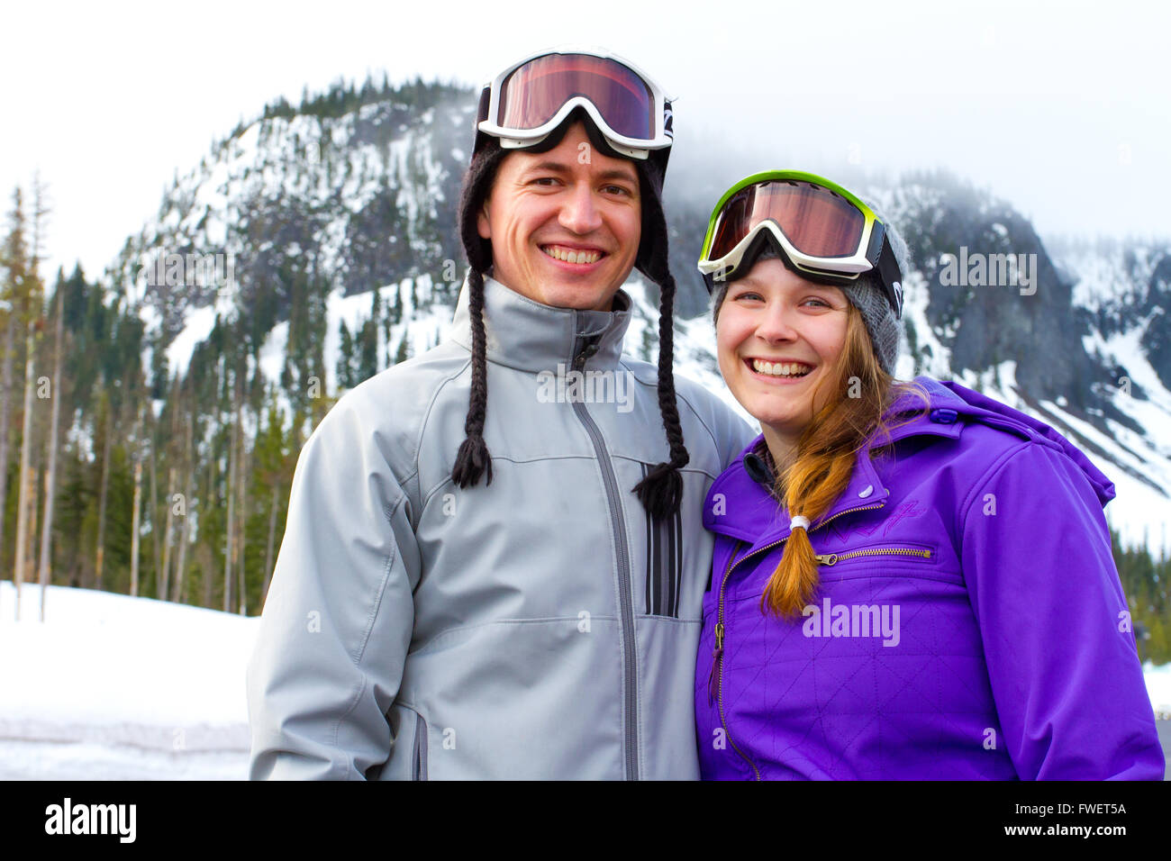 A happy couple together on the mountain resort in the snow for a day of ...