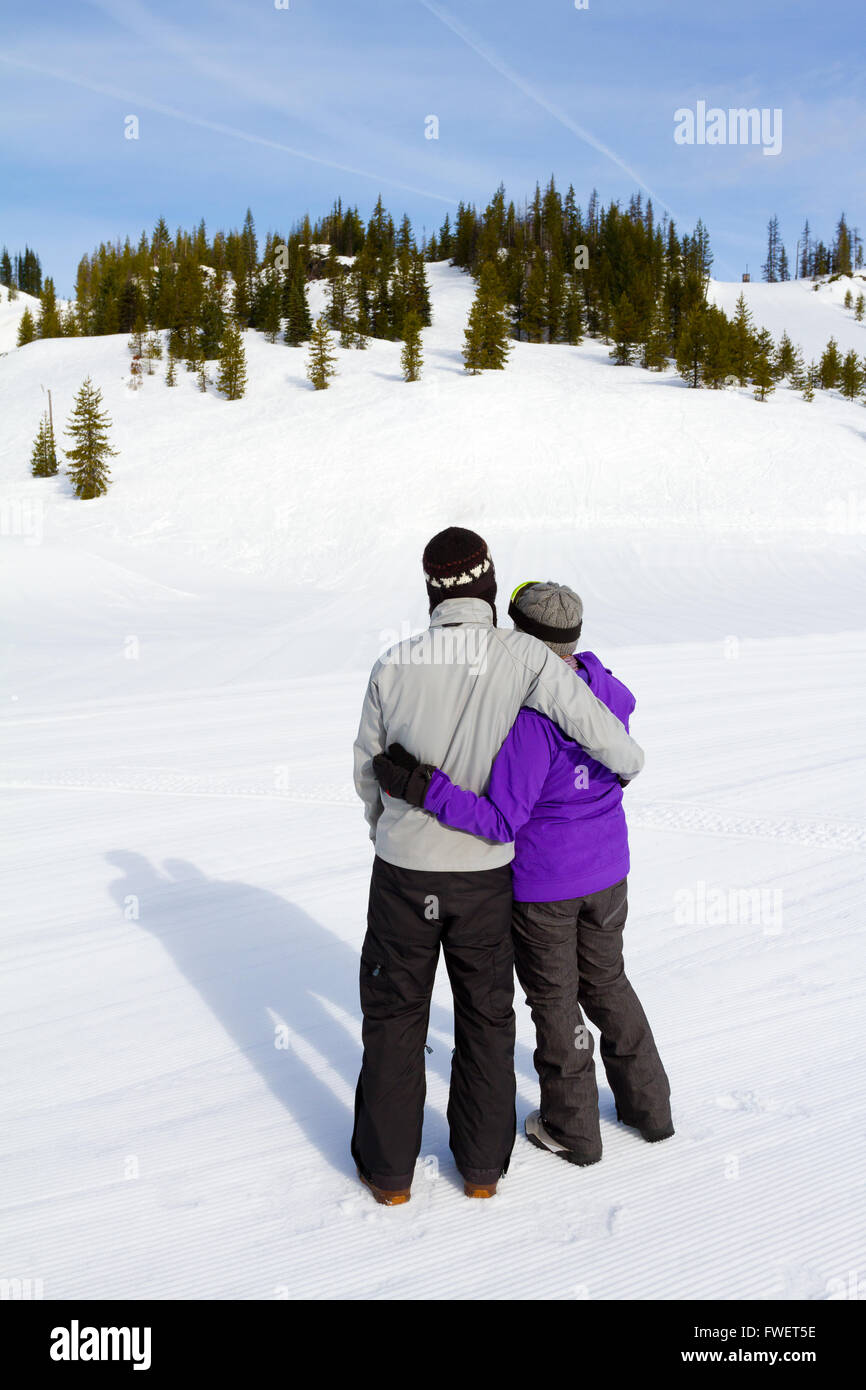 A happy couple together on the mountain resort in the snow for a day of ...