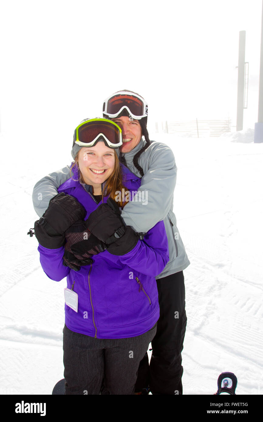 A happy couple together on the mountain resort in the snow for a day of ...