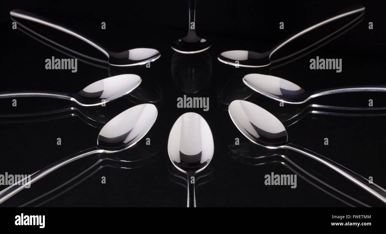 Teaspoons on the black glass desk Stock Photo - Alamy