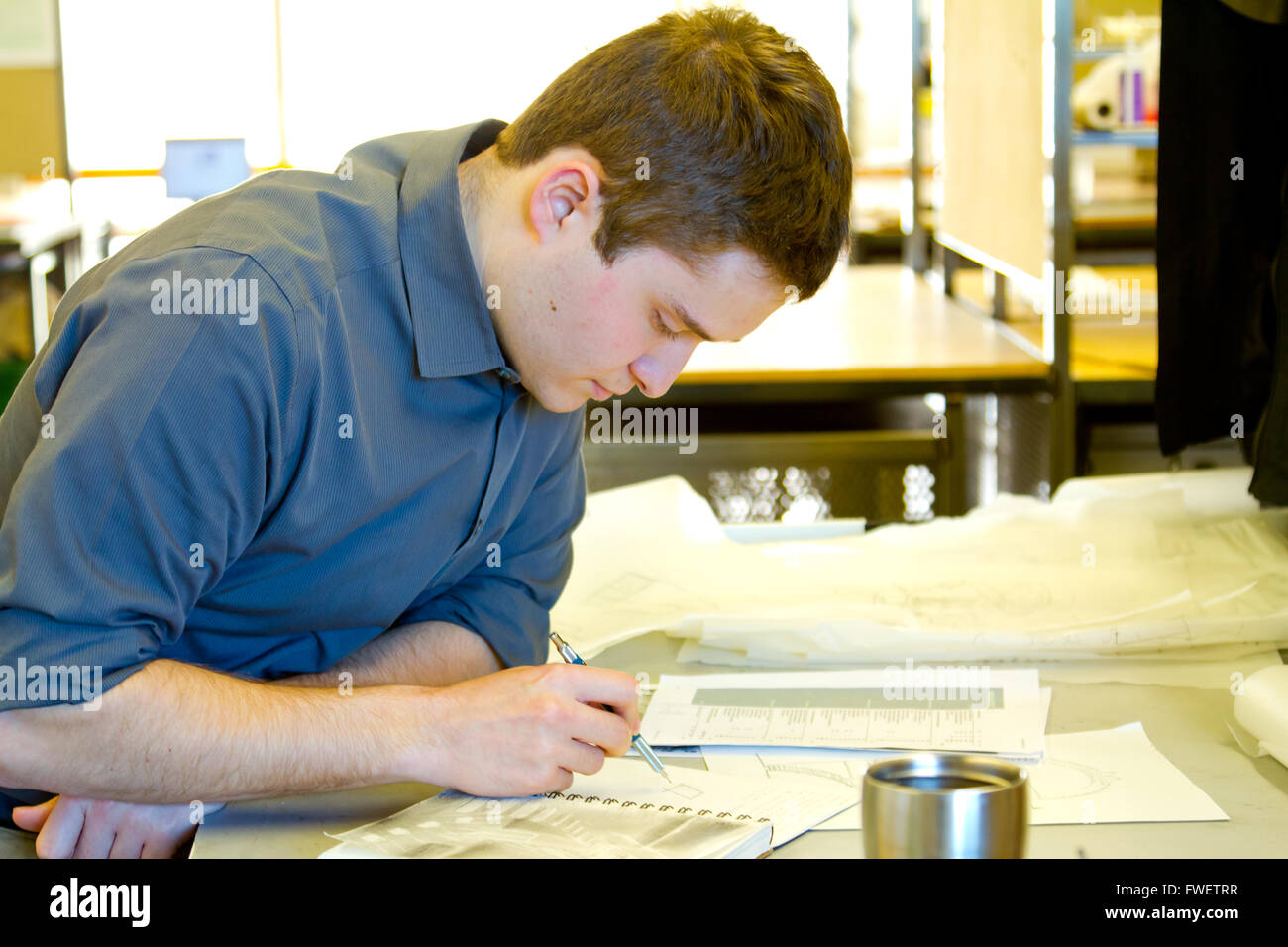 An architect studies in his college work building while drawing plans ...