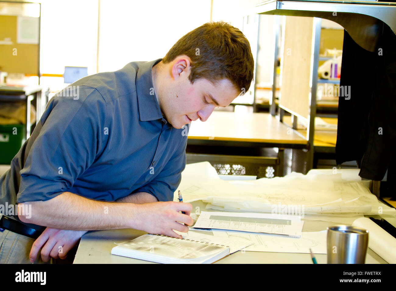 An architect studies in his college work building while drawing plans ...