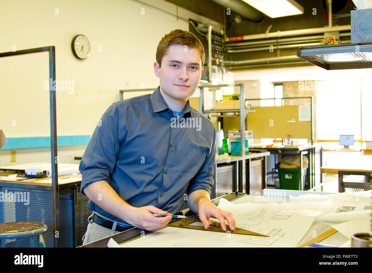 An architect studies in his college work building while drawing plans ...