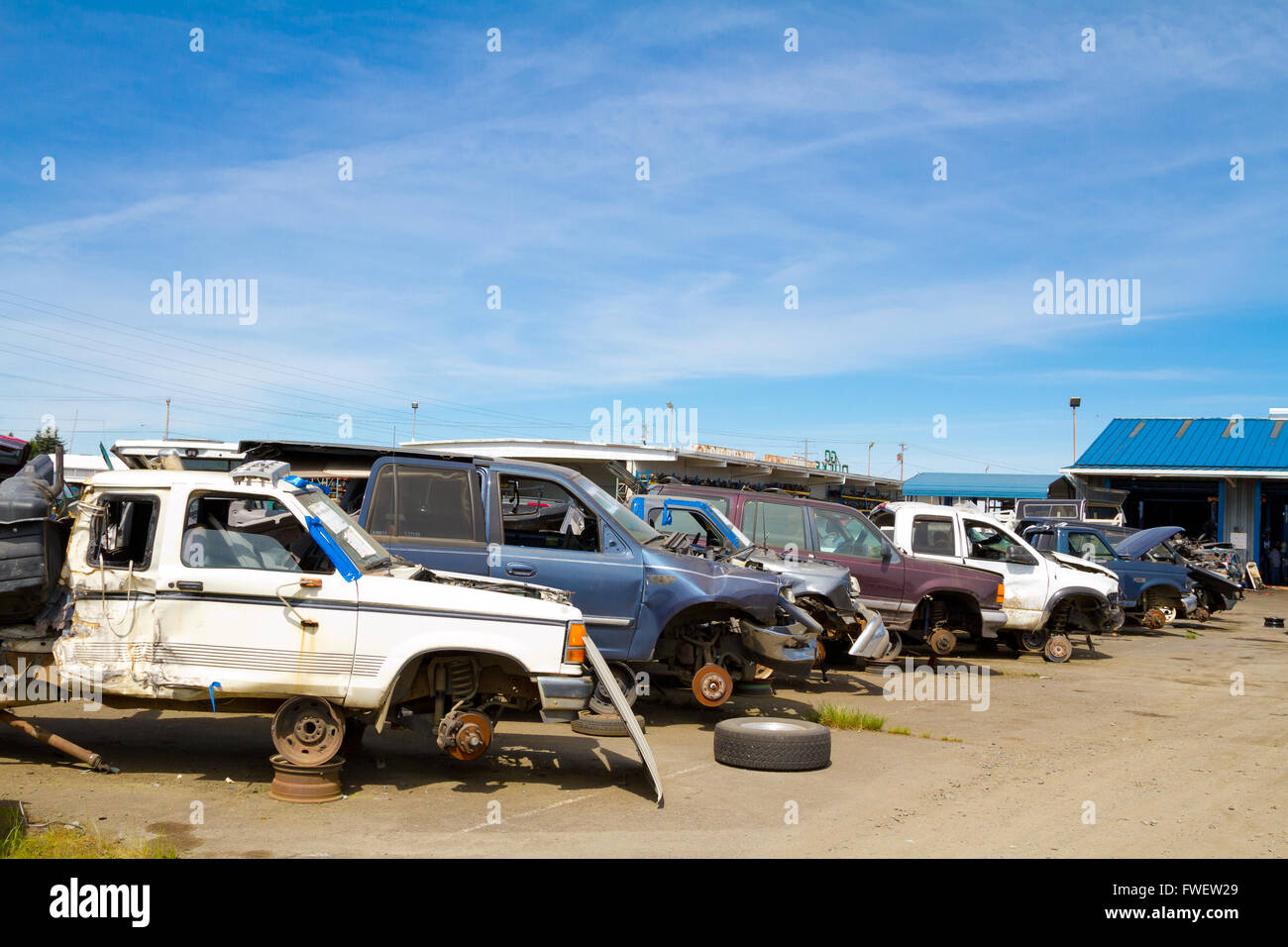 The scene shows many cars and other automobiles in a salvage junk yard ...