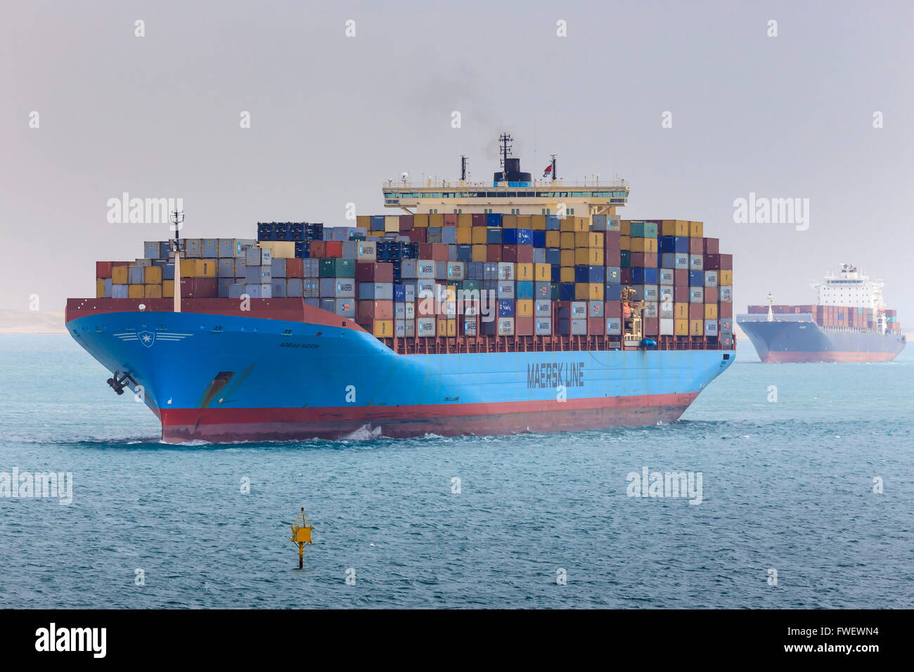 Convoy of container ships transiting the Suez Canal loom through air ... Convoy of container ships transiting the Suez Canal loom through air ...