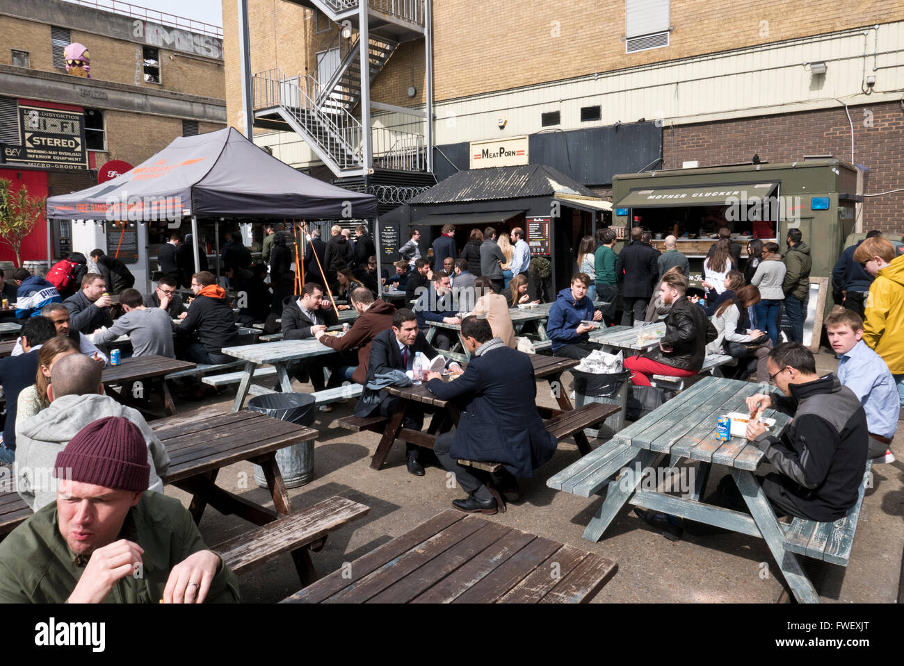 People eating fast food and drinking in an outdoor restaurant in London ...