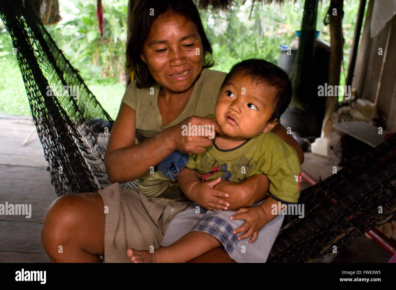A woman with her child in a hammock in the riverside village of ...