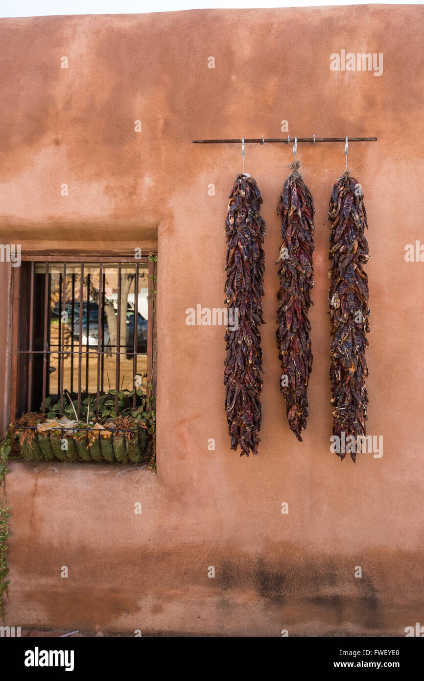 Dried chile pepper ristras hang on an adobe wall in the Old Town Plaza ...