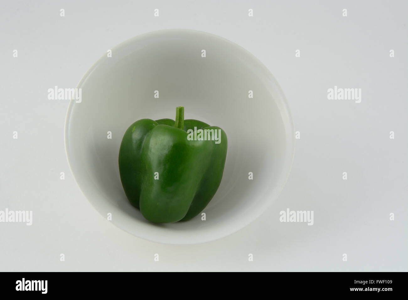 Green bell pepper in white bowl Stock Photo - Alamy