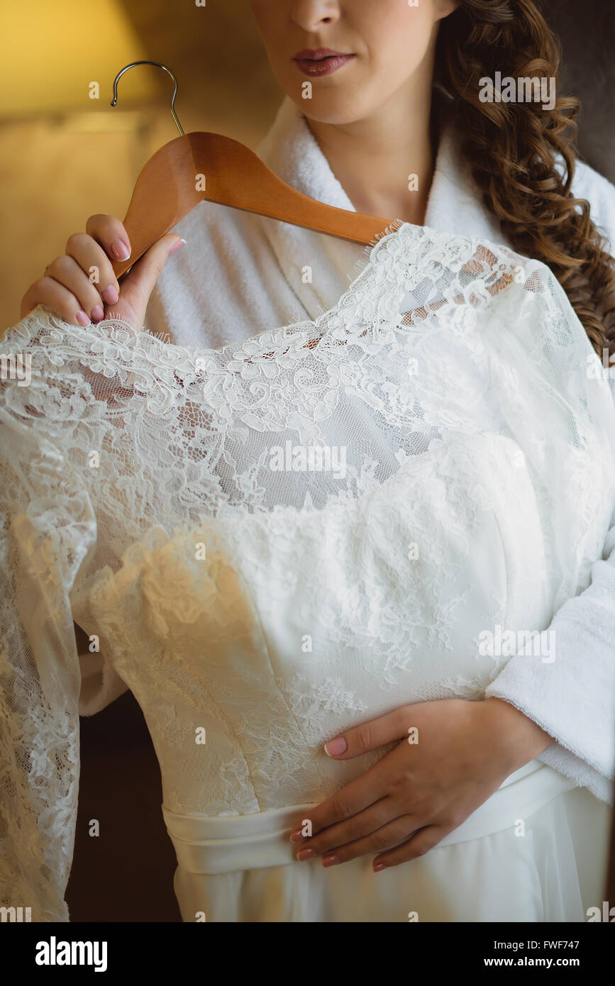 Bride holding wedding dress Stock Photo - Alamy
