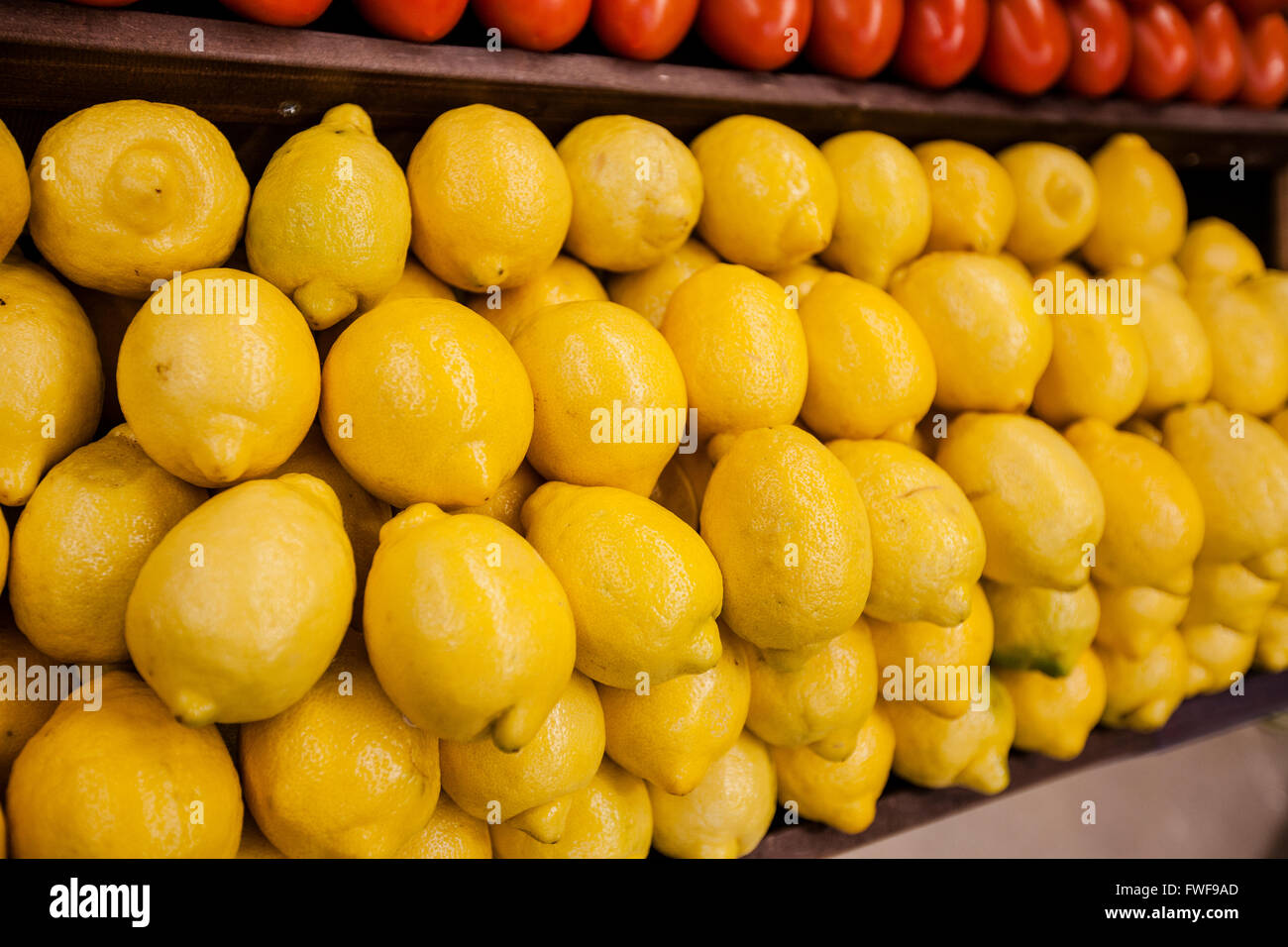 A stack of rows of lemons in the produce section of a grocery store ...