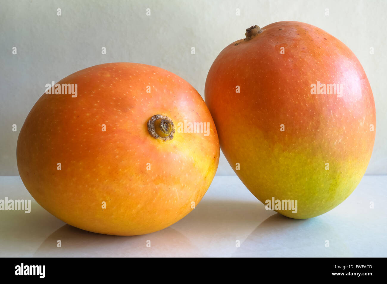 Two ripe orange mangoes Stock Photo - Alamy