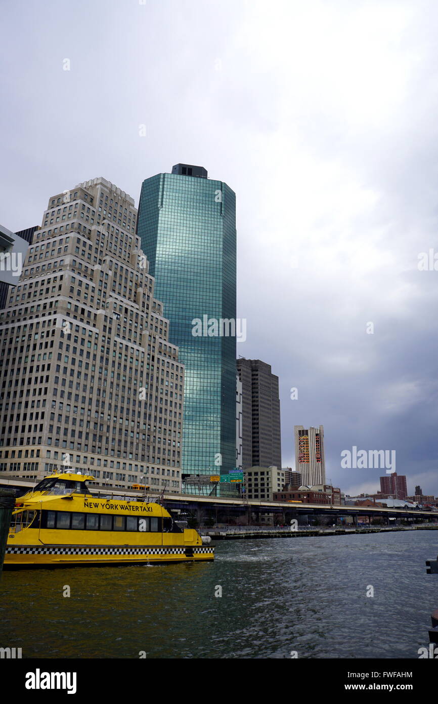 Water taxi at Pier 11 with the backdrop of Lower Manhattan skyscrapers ...