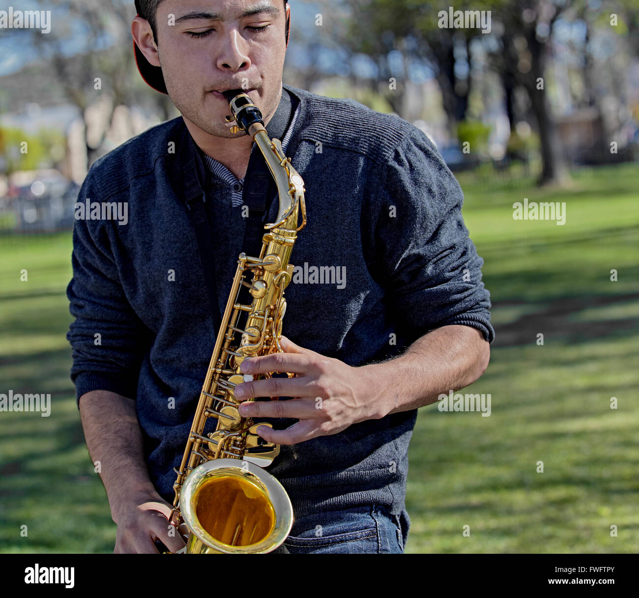 College Student playing the Saxophone in a Park Stock Photo - Alamy