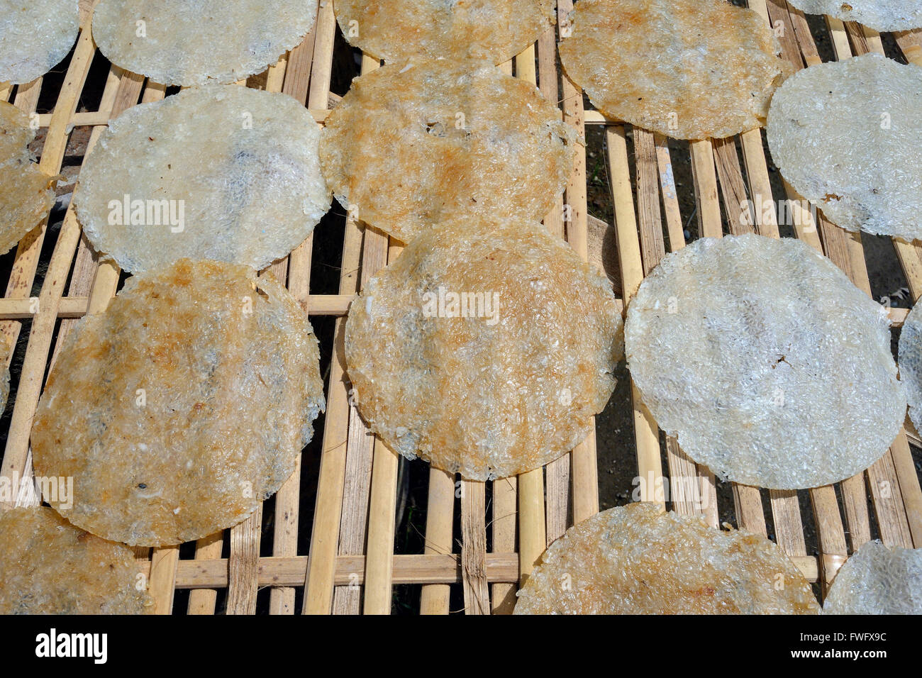 Round flat rice cake drying on bamboo rack, Bali, Indonesia Stock Photo ...