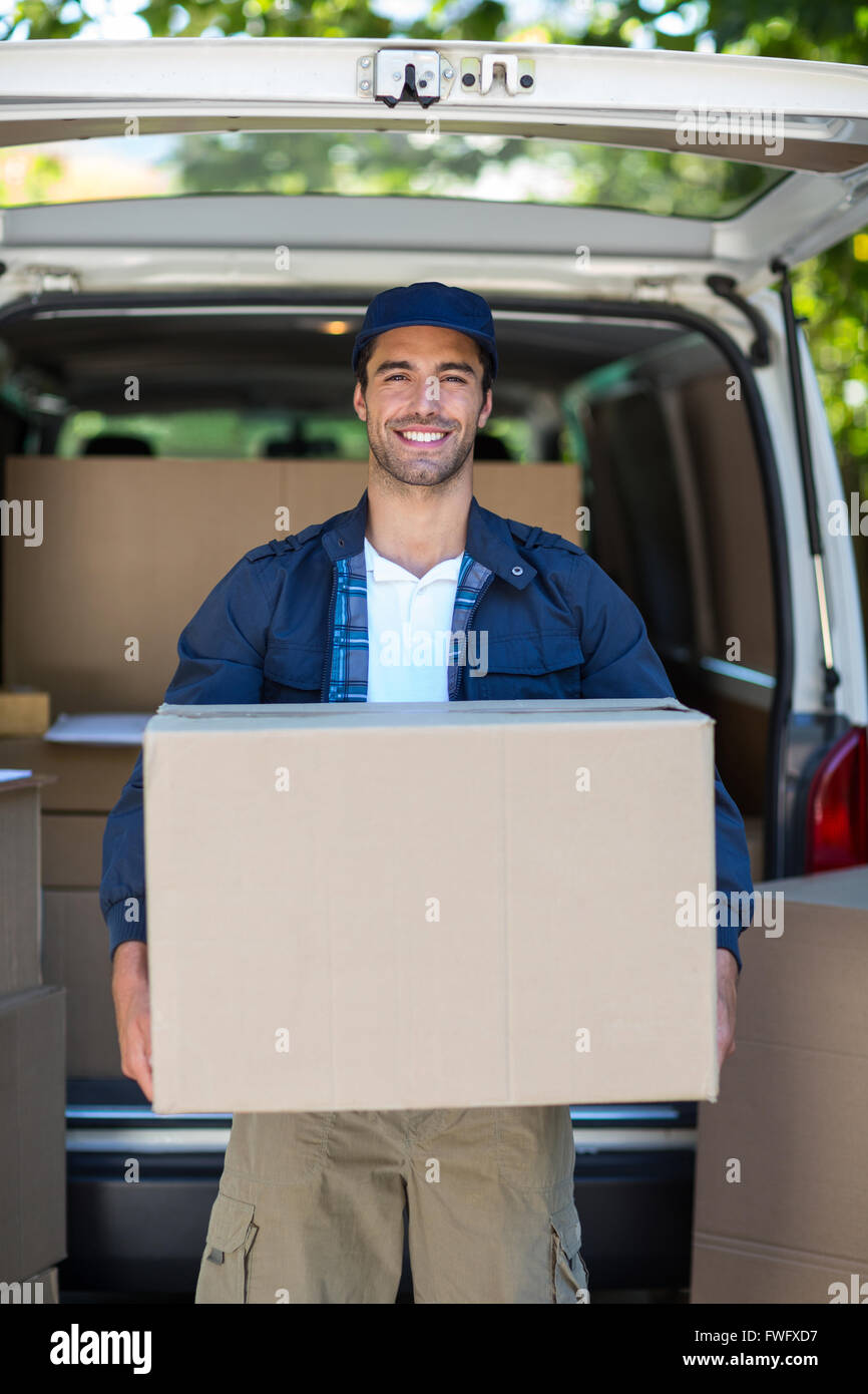 Portrait of smart delivery man carrying cardboard box Stock Photo - Alamy